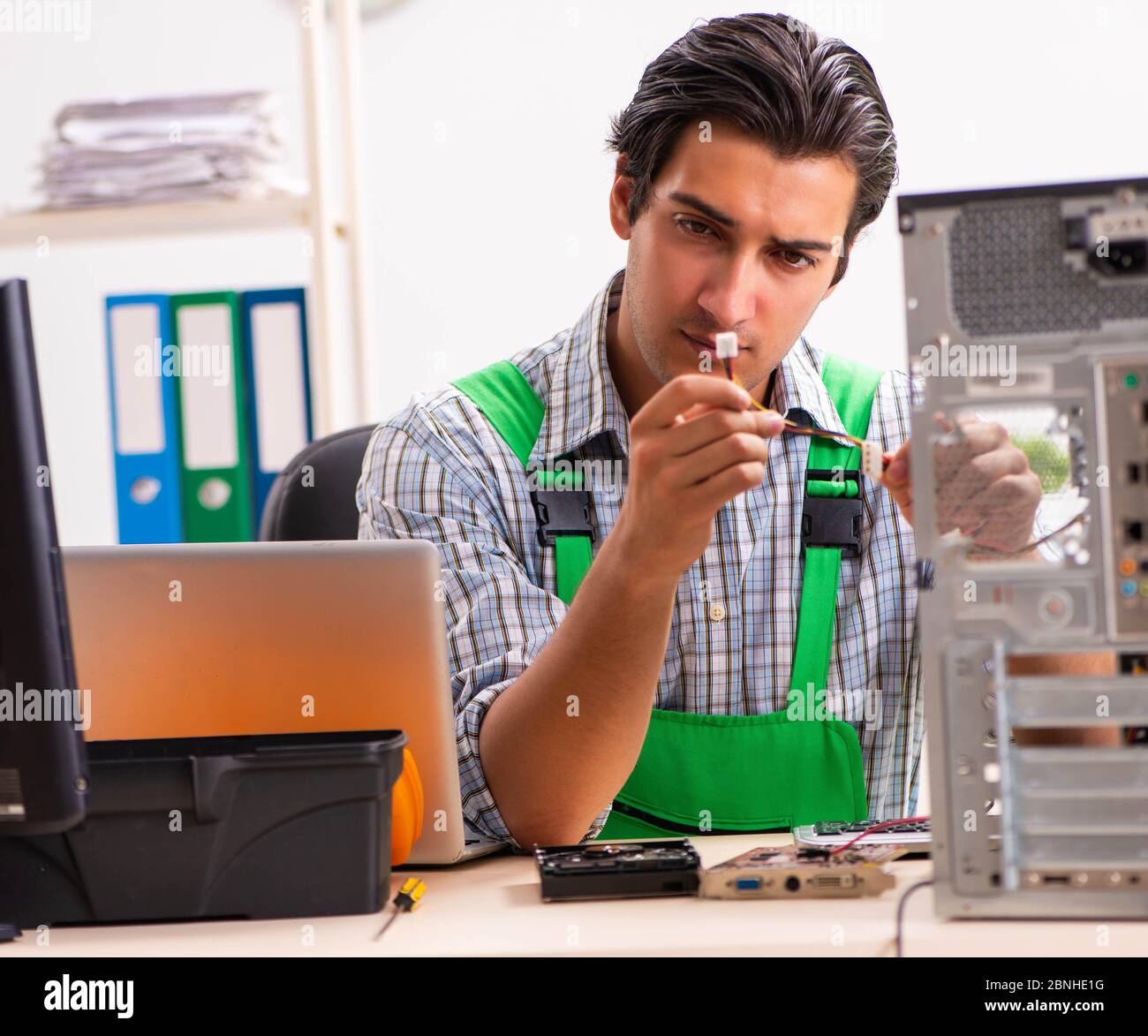The young engineer repairing broken computer at the office Stock Photo ...