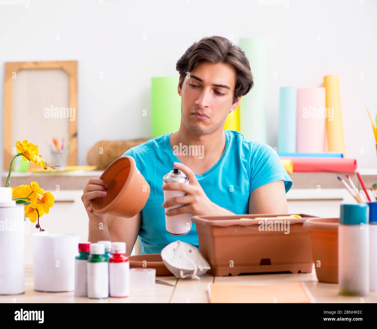 The young man decorating pottery in class Stock Photo - Alamy