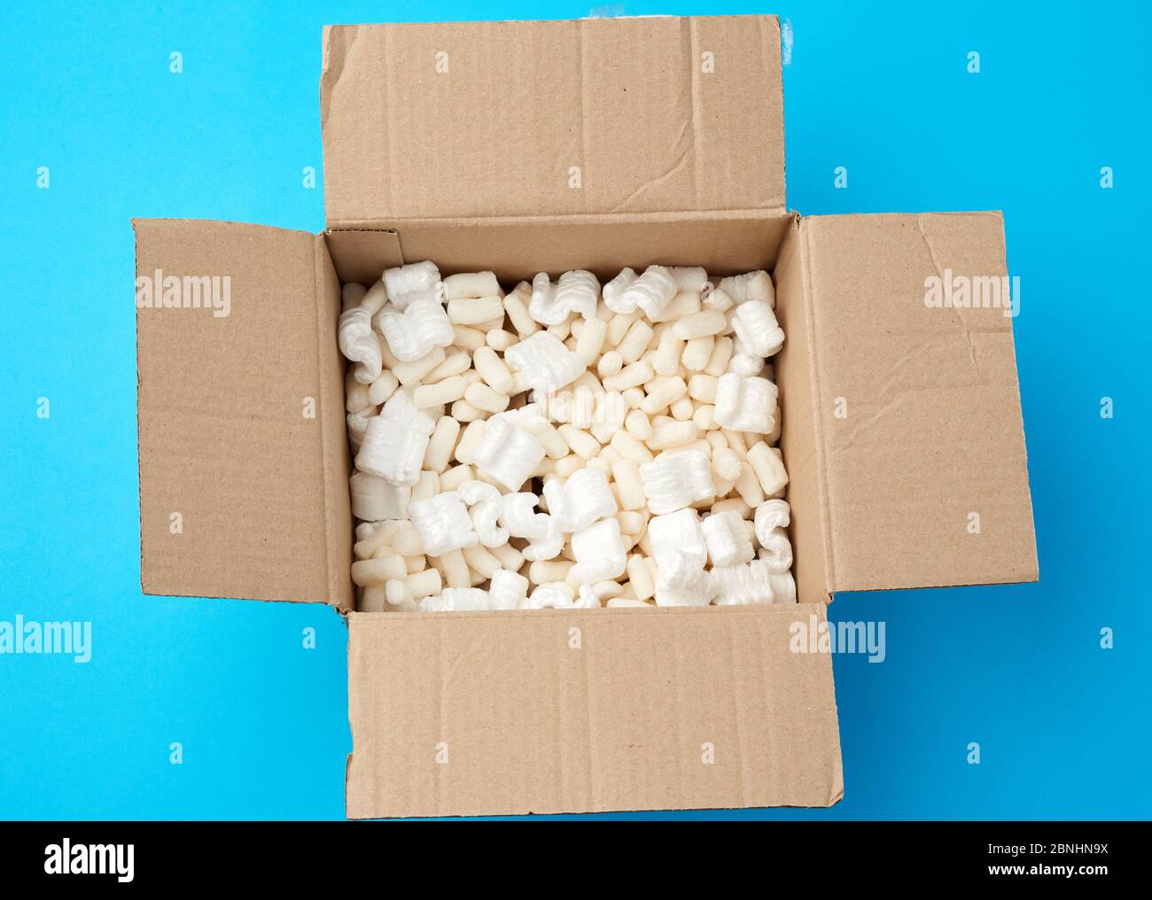 open brown cardboard box with white foam filling for transporting goods ...