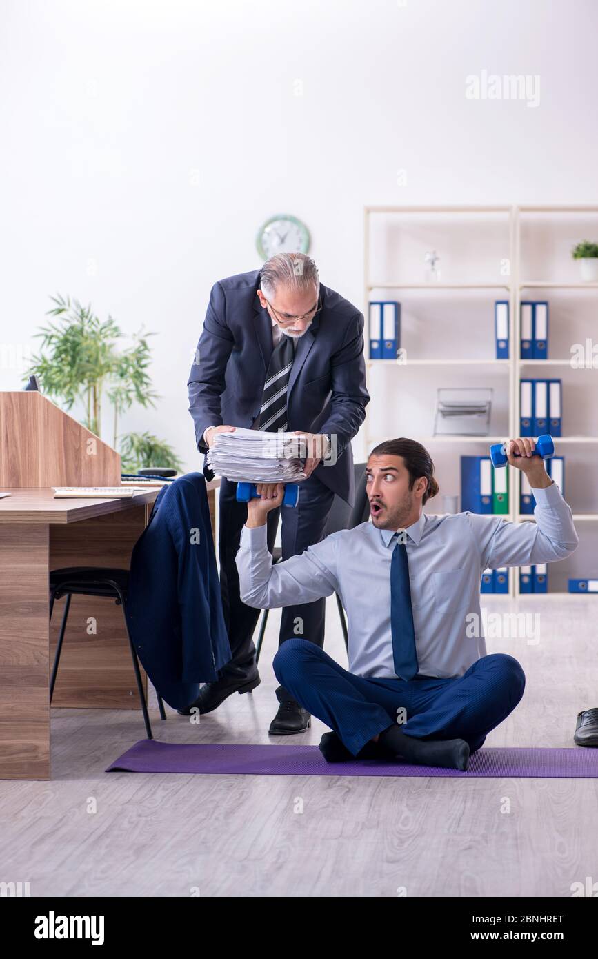 Two employees doing physical exercises at the workplace Stock Photo - Alamy
