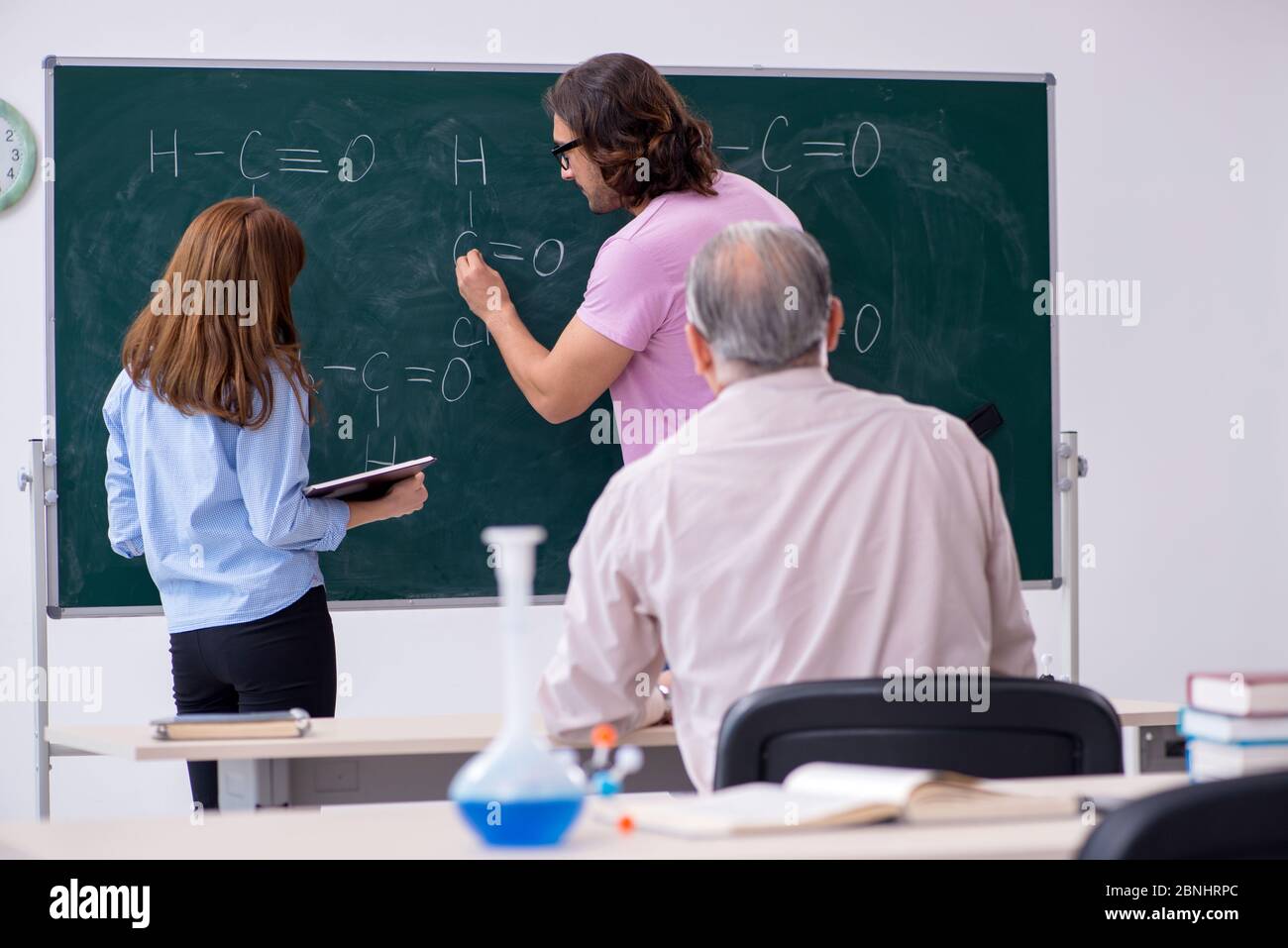 Old teacher and two students in the classroom Stock Photo - Alamy