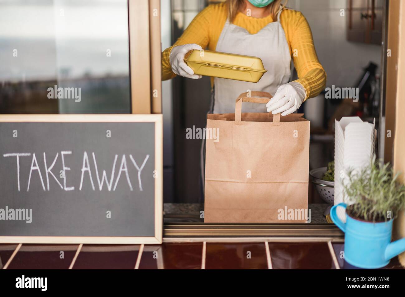 Young woman preparing takeaway organic food inside restaurant during ...