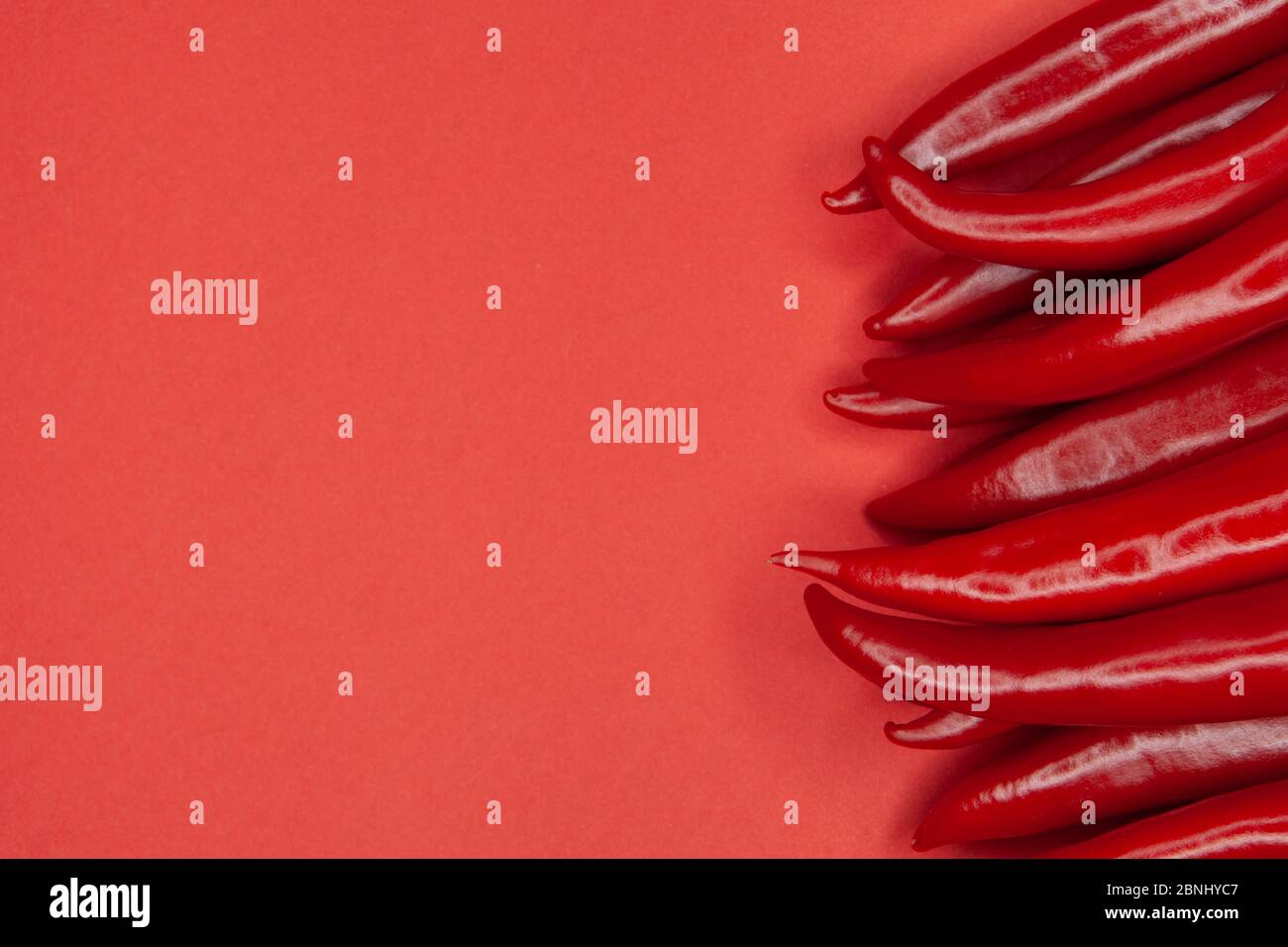 Red hot chili peppers on a red background Stock Photo - Alamy