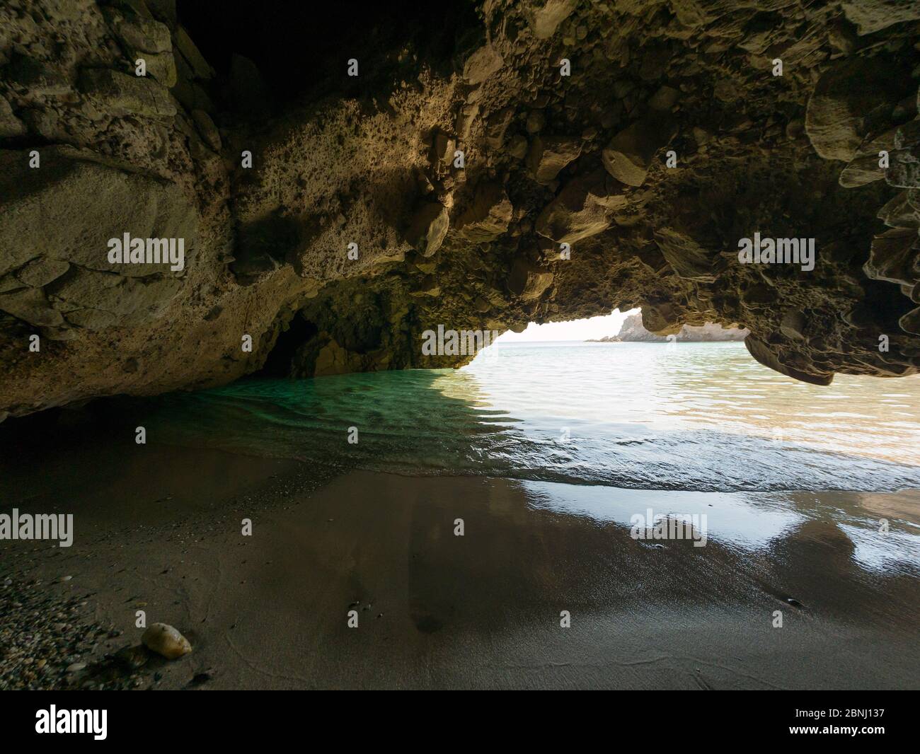 Small cave in Tsigrado beach with crystal clear water in Milos island ...