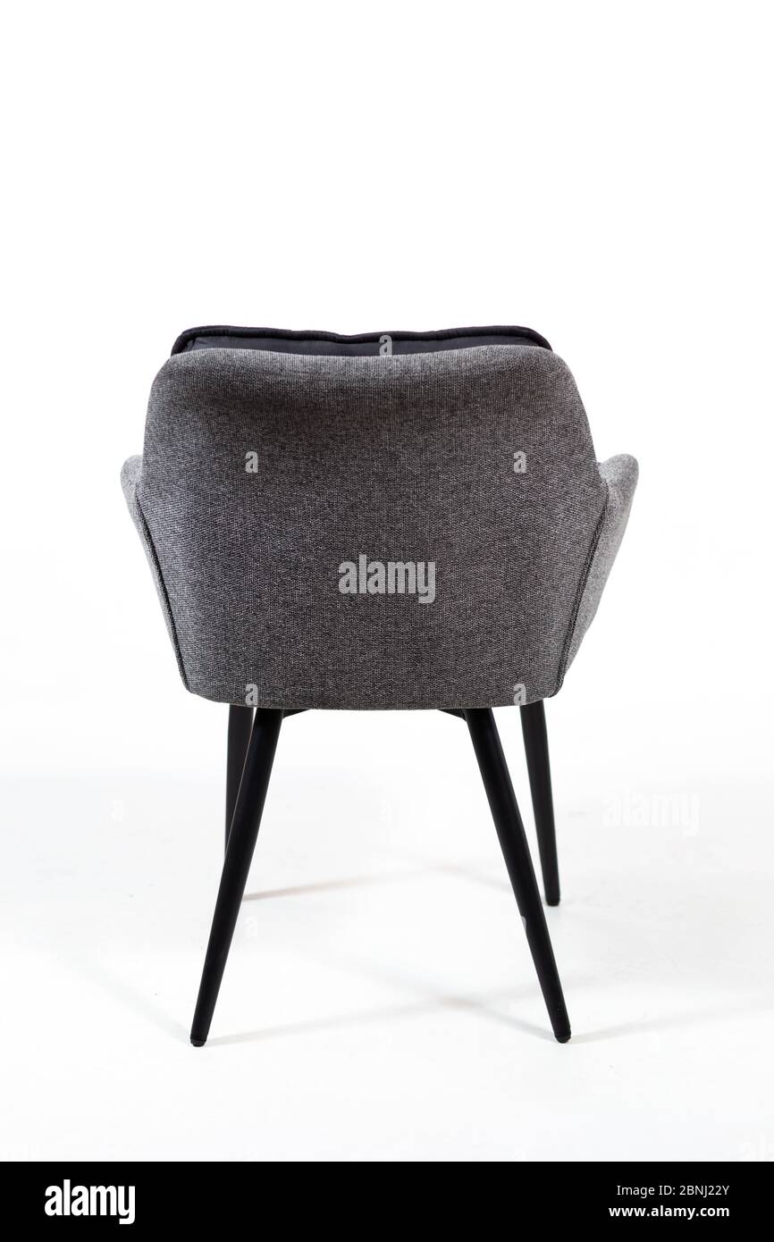 Vertical shot of the back of a gray chair behind a white background ...
