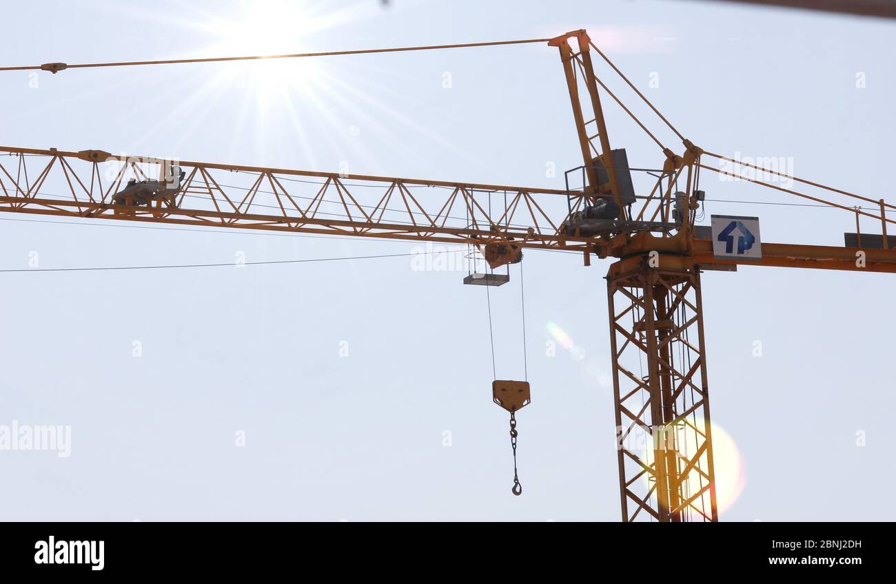 Tower crane with a sun effect Stock Photo - Alamy