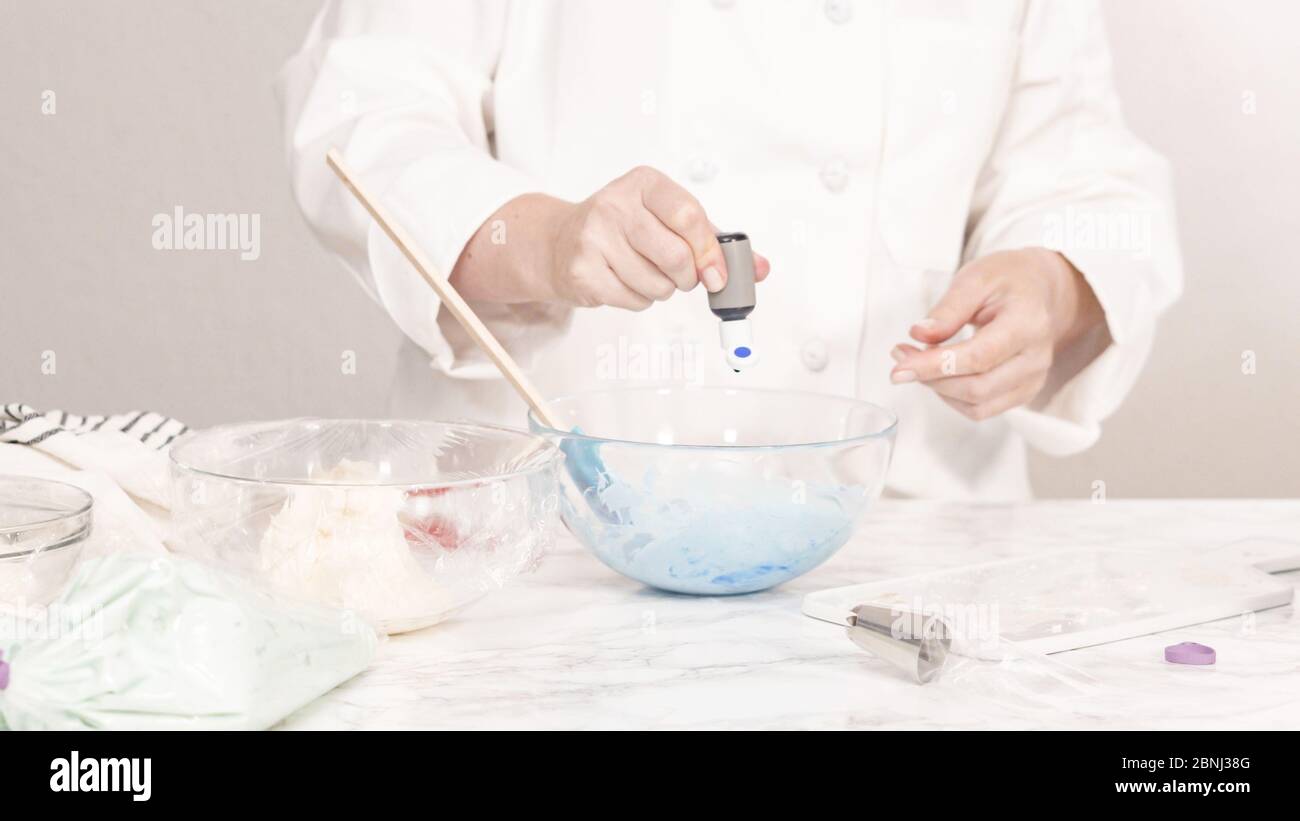 Mixing food coloring with buttercream frosting Stock Photo - Alamy