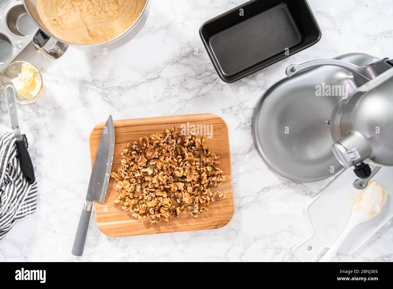 Flat lay. Chopping walnuts into small pieces with kitchen knife on a ...