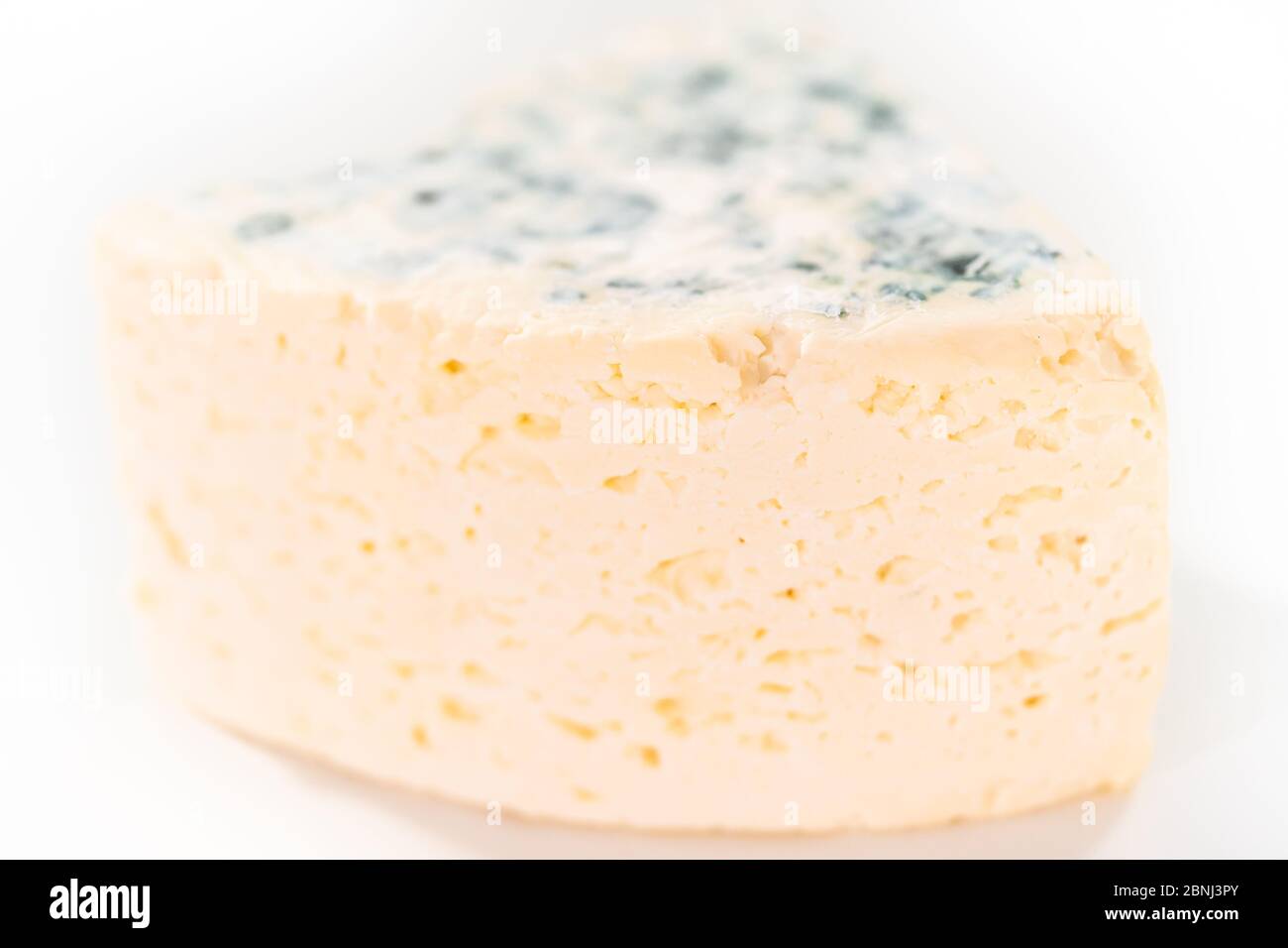 Large slice of blue cheese on a white background Stock Photo - Alamy