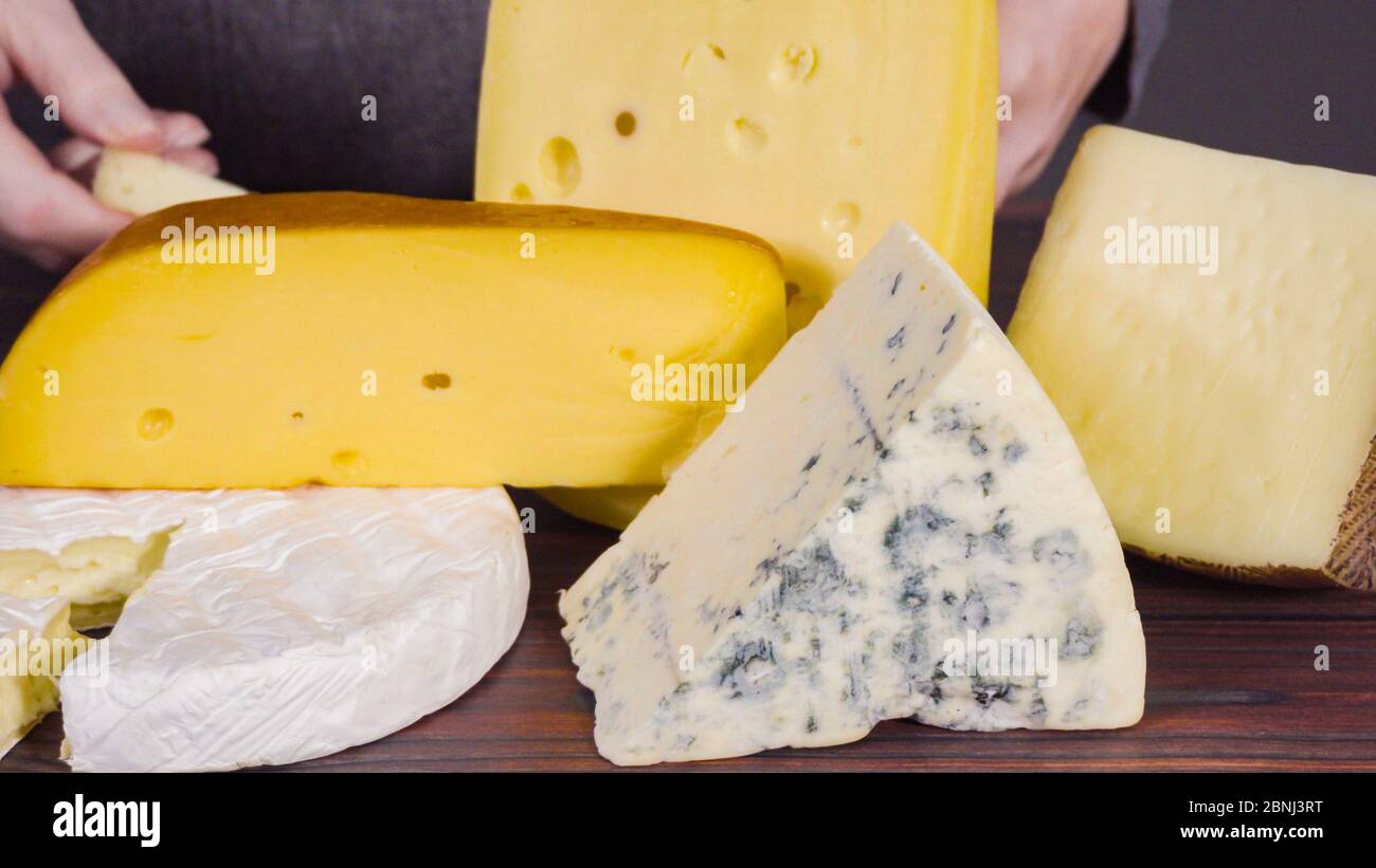 Large wedges of gourmet cheese on a rustic wood background Stock Photo ...