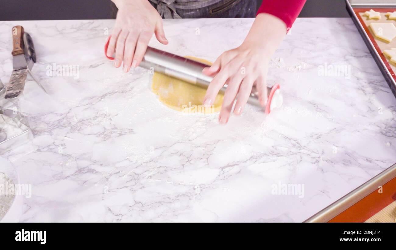Rolling out sugar cookie dough to bake Christmas cookies Stock Photo ...