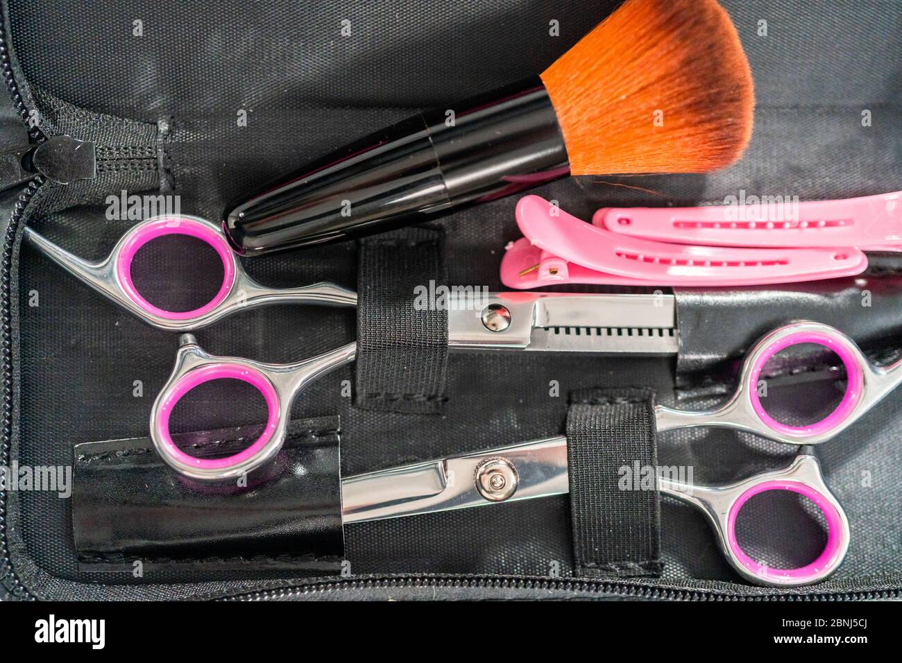 New barber set with pink scissors on a gray background Stock Photo - Alamy