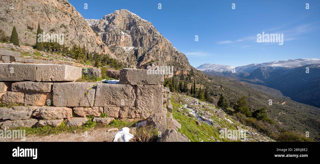 Ruins of Delphi archaeological site with snow in a winter day with sun ...