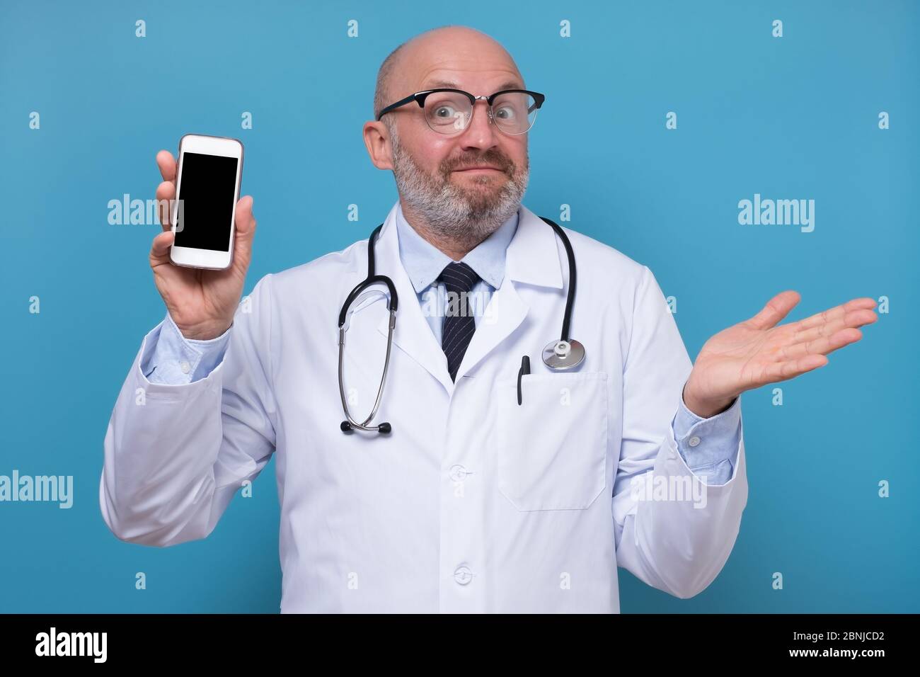 Mature male doctor shows blank screen of smartphone Stock Photo - Alamy