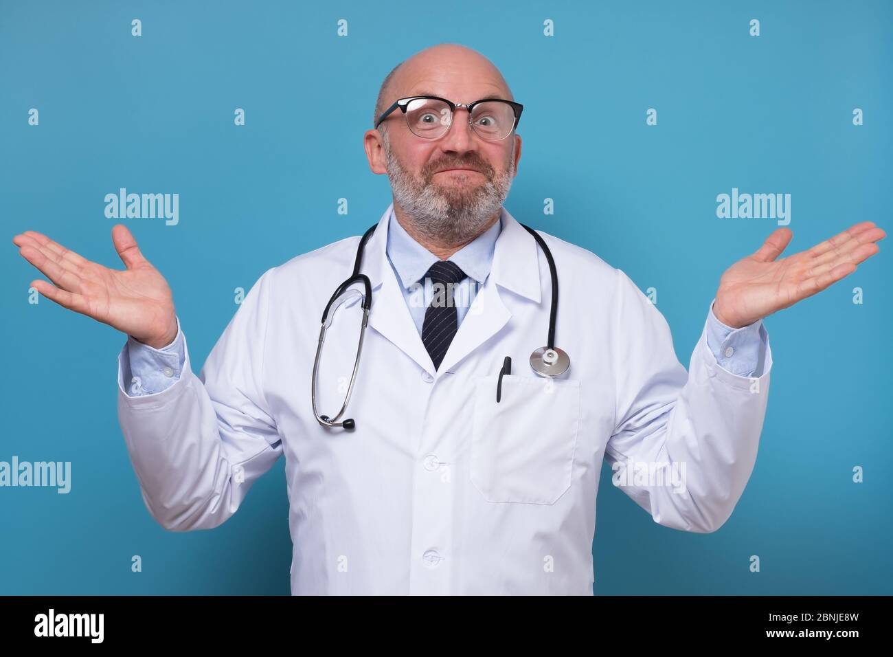 Mature male doctor shrugging lifting shoulders having no idea how to ...