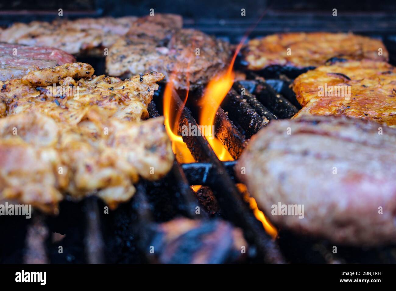 Meat being flame grilled on a barbecue, BBQ flame grill Stock Photo - Alamy