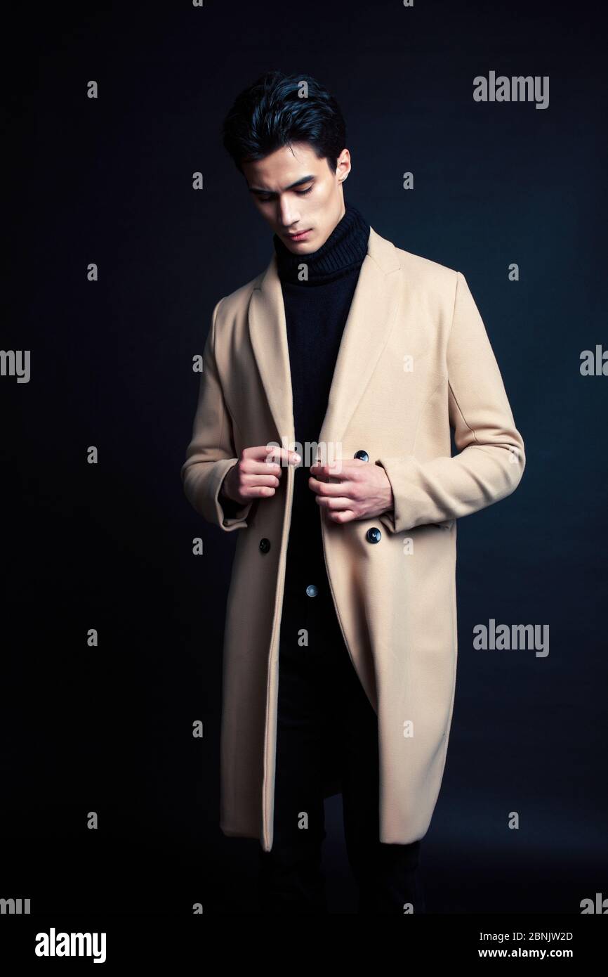 handsome asian fashion looking man posing in studio on black background ...