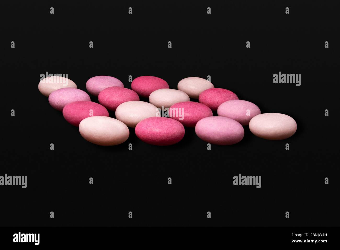 Group gradient pink drops candies isolated on black background Stock ...