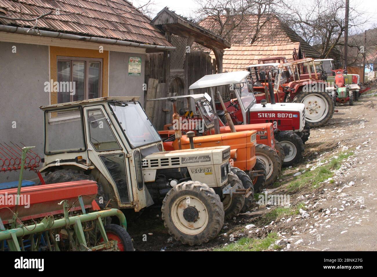 Lots of tractors parked in front of a house in countryside Romania ...