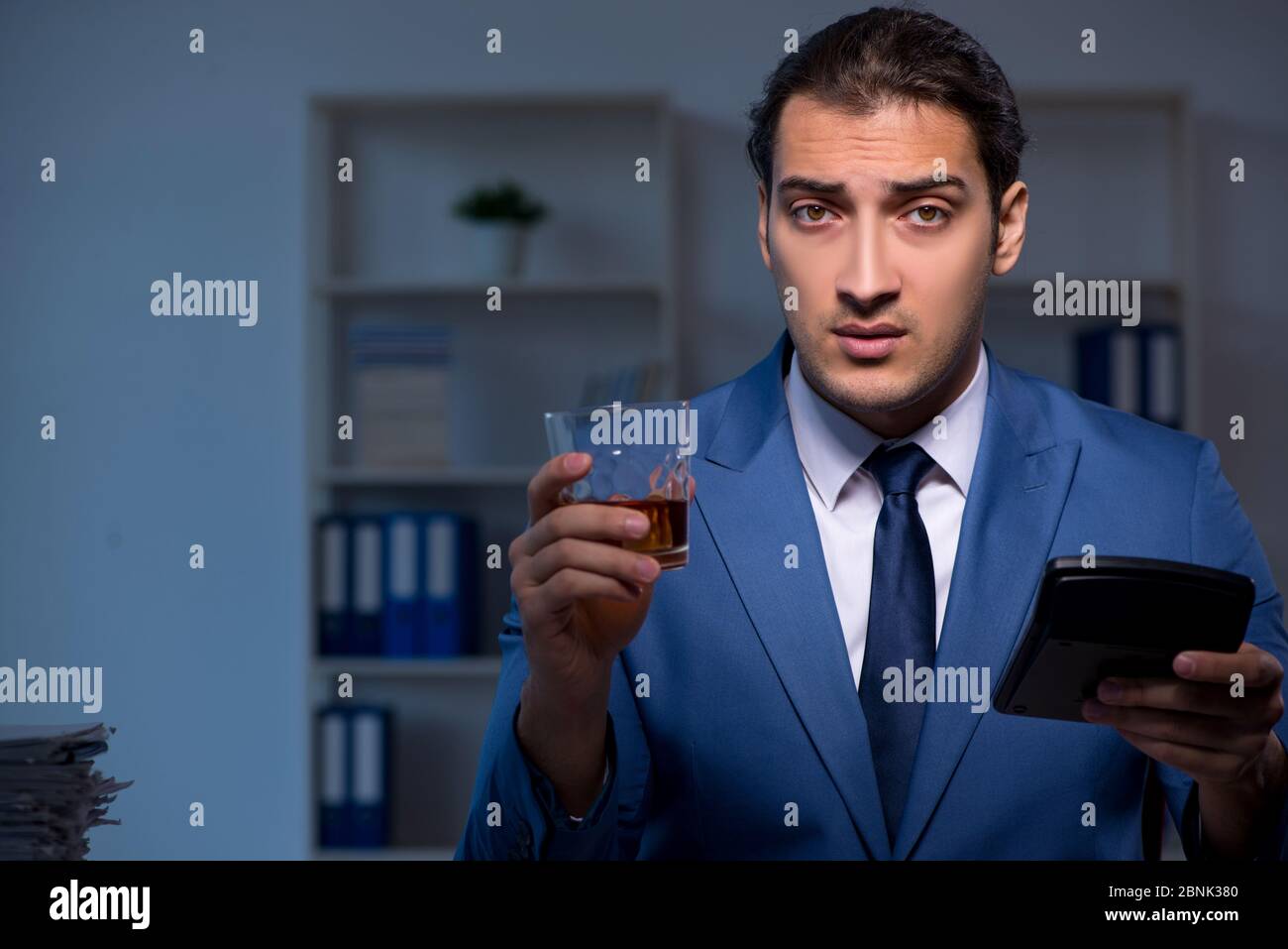 Alcohol addicted businessman working late Stock Photo - Alamy