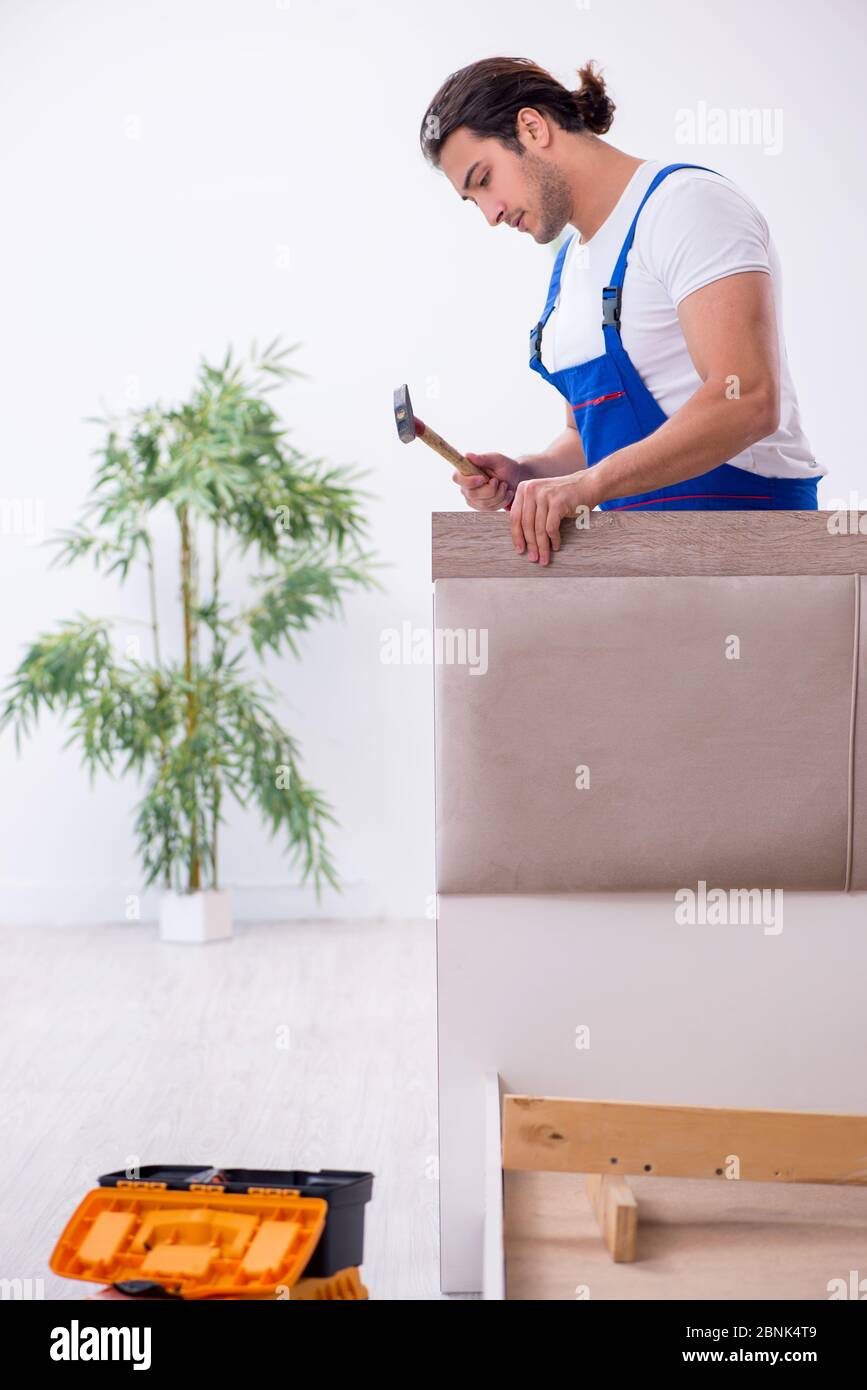 Young contractor installing furniture at home Stock Photo - Alamy