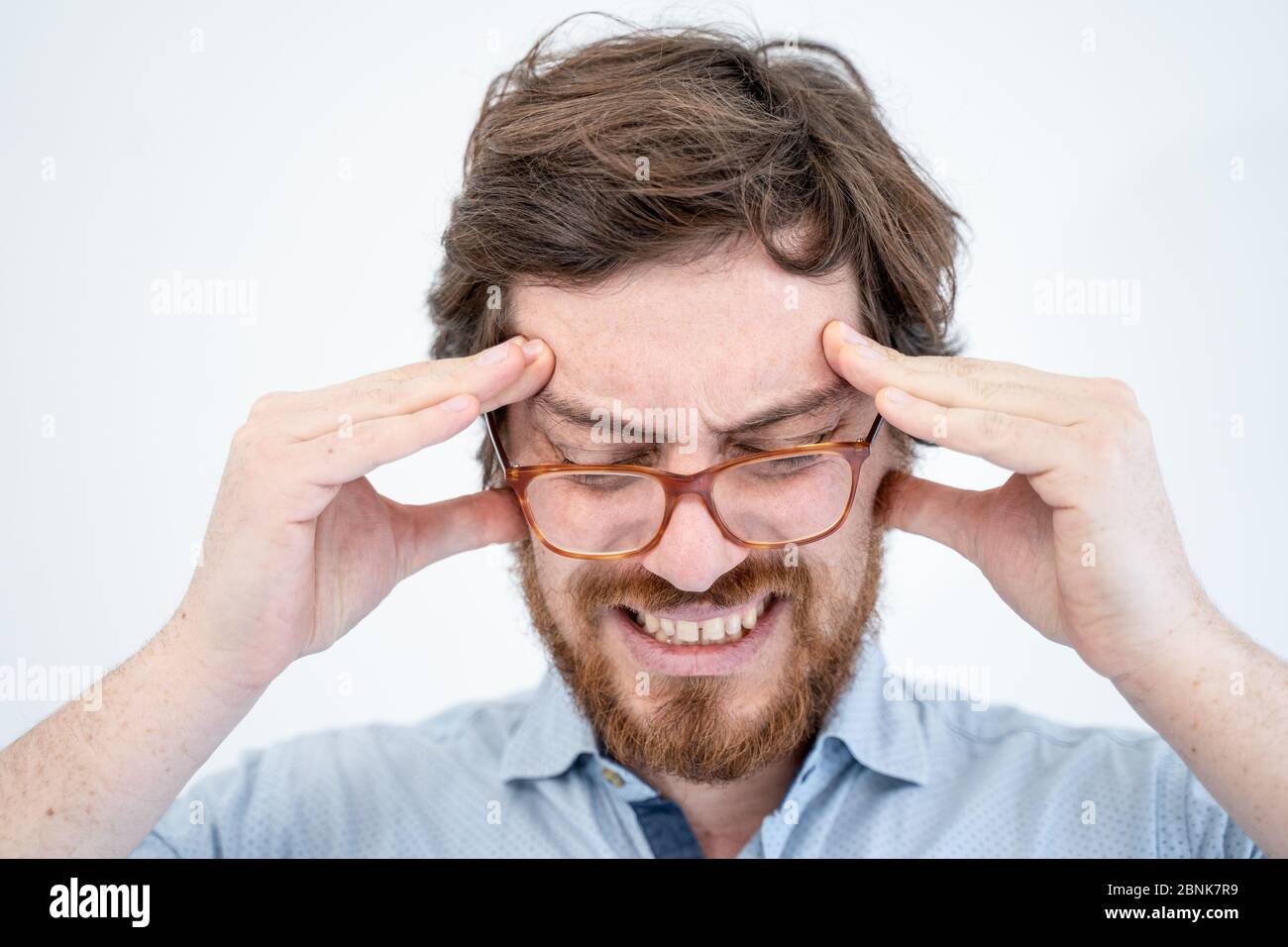 Man face close up feeling head pain on white background Stock Photo - Alamy