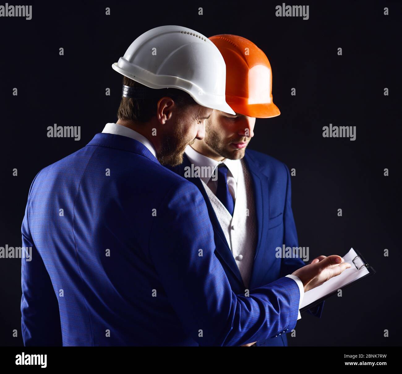 Builders look at engineering project. Entrepreneur and employee with ...