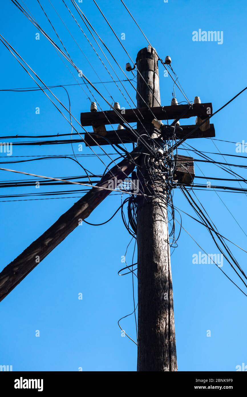 Wooden pole with a transformer, conductors and various cables. Abstract ...