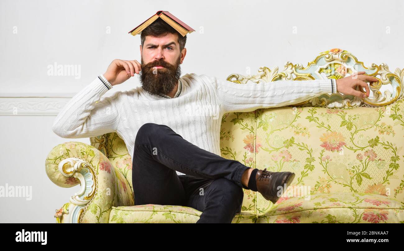 Macho sits with open book on head, like roof. Man with beard and ...