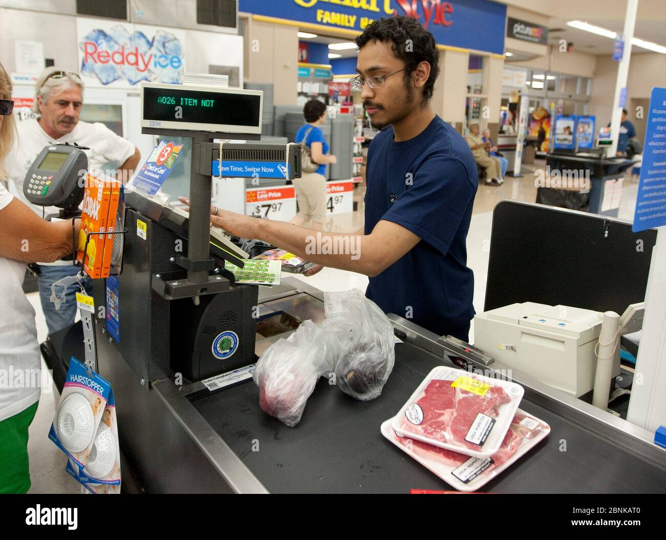 San Marcos, Texas USA, 2012: Young Hispanic male cashier concentrates ...