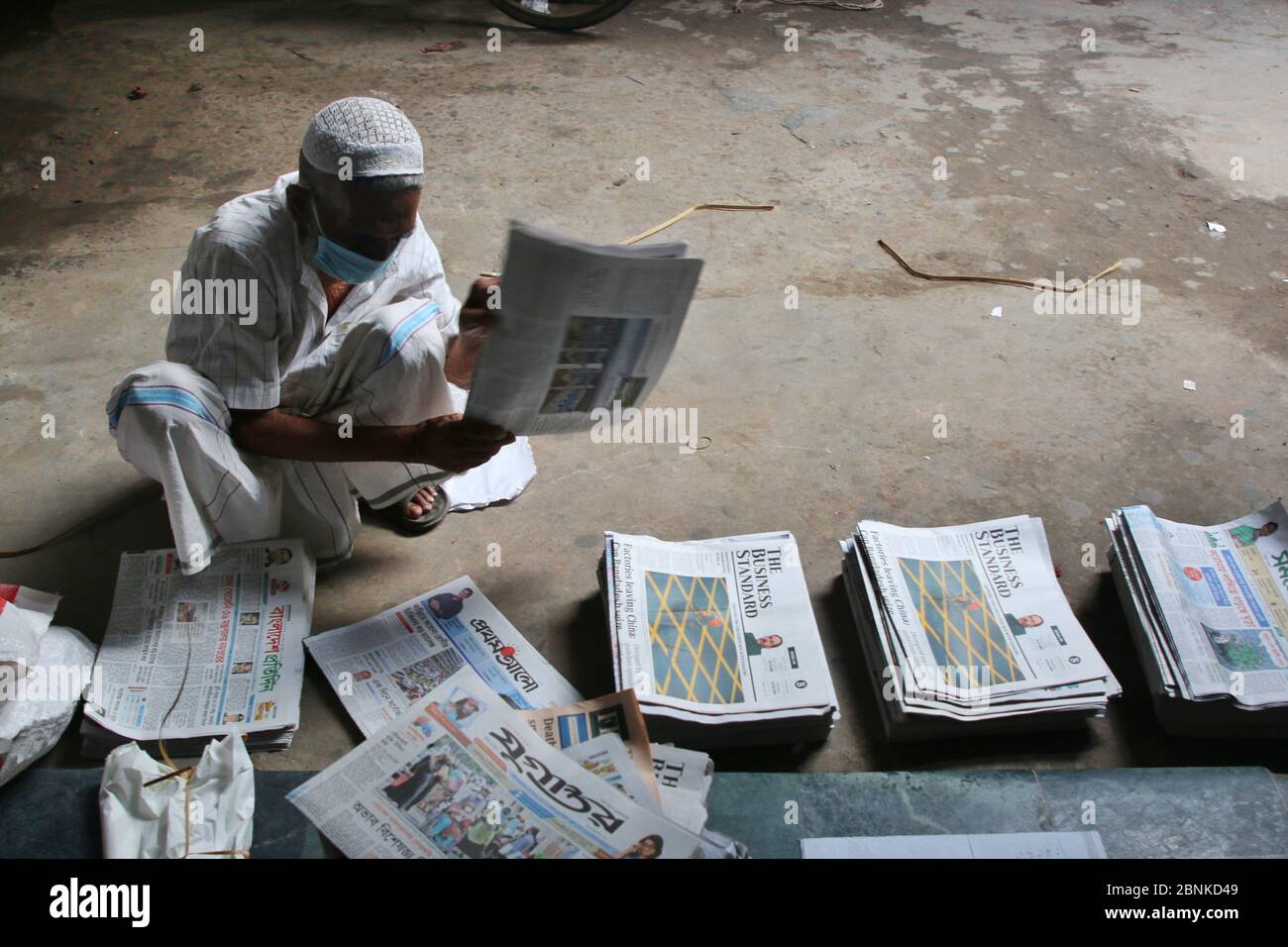 An old Newspaper hawker wearing a face mask as a preventive measure ...