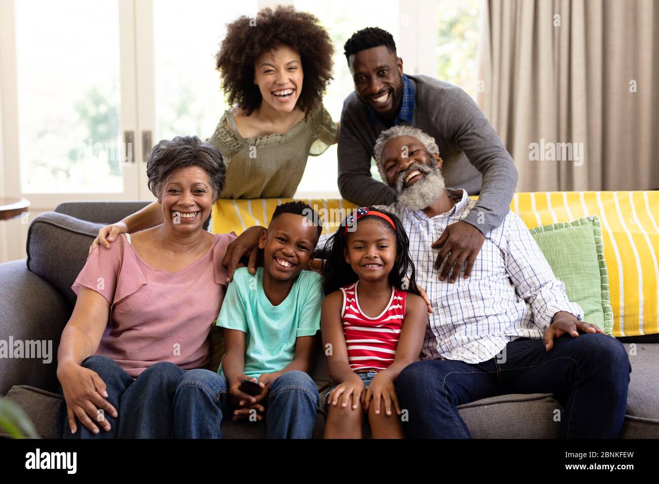 Multi generation mixed race family spending time together sitting on a ...