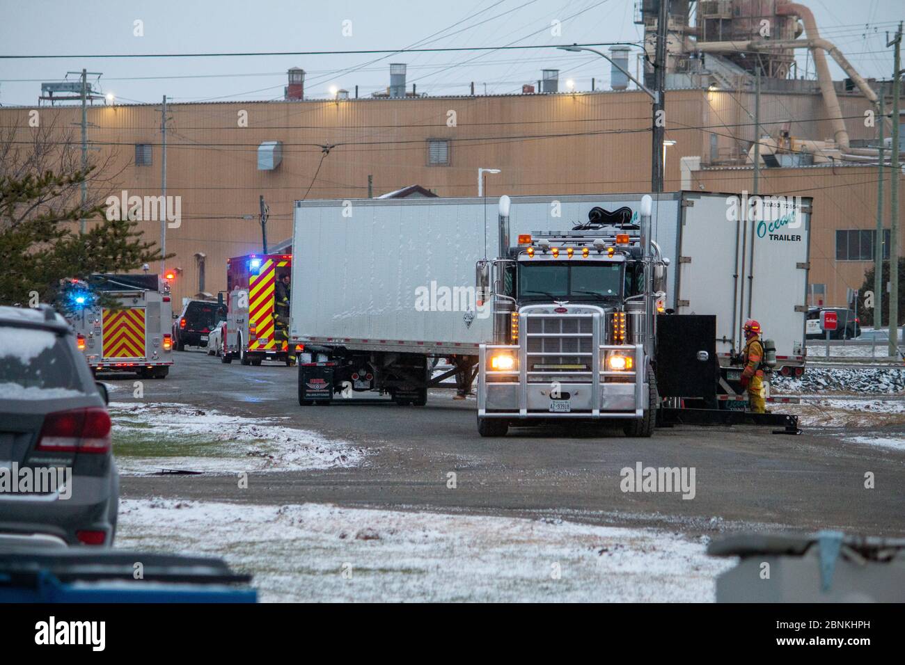 Tow truck pulling a transport from a ditch with emergency crews nearby ...