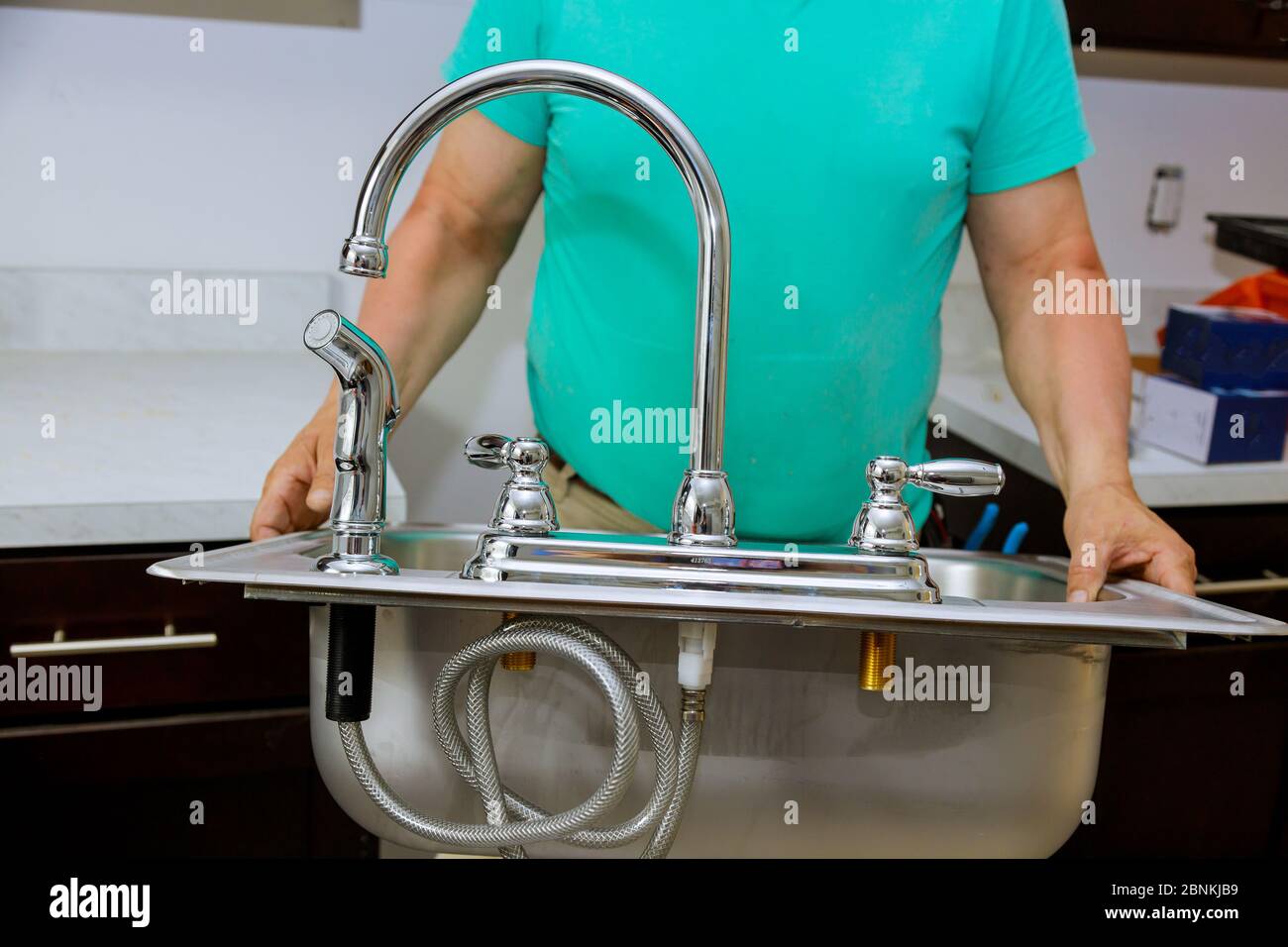 Professional plumber master sets the sink in the kitchen is near the ...
