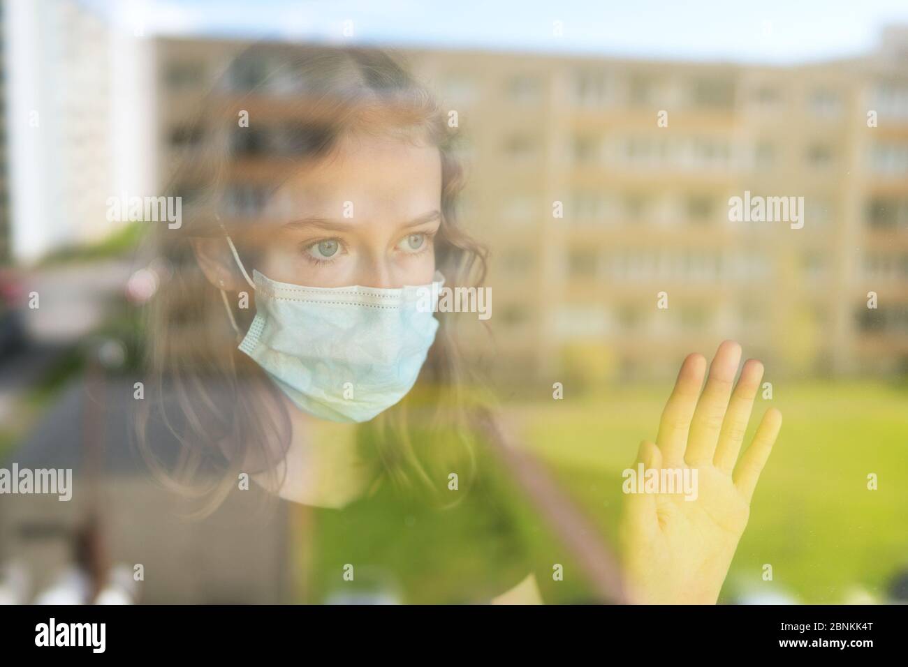 Little girl behind the window during self isolation. Stay home Stock ...