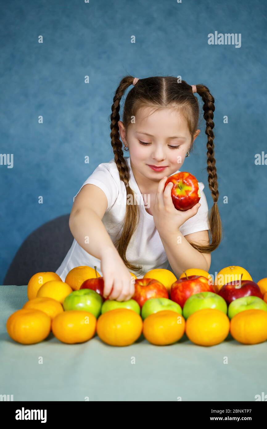 Little girl in white T-shirt love fruit Stock Photo - Alamy