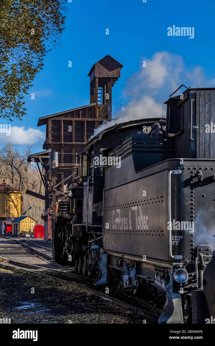 Steam locomotive building steam for work hauling passengers, at the ...