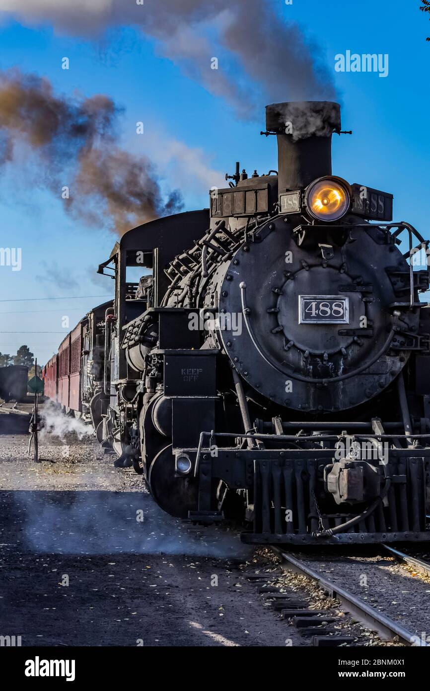 Steam locomotive building steam for work hauling passengers, at the ...