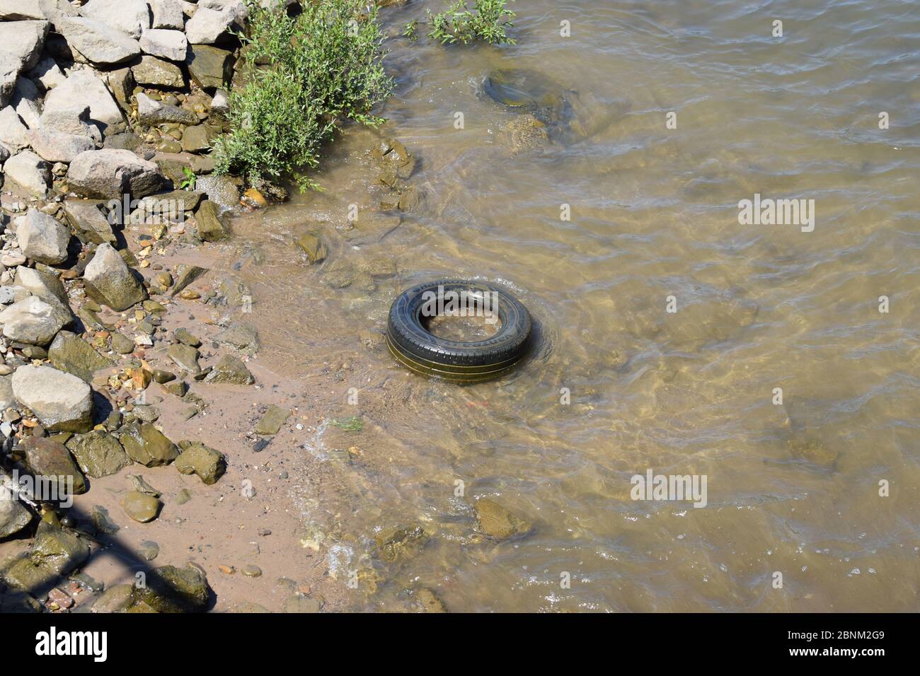 tire in the river Stock Photo - Alamy