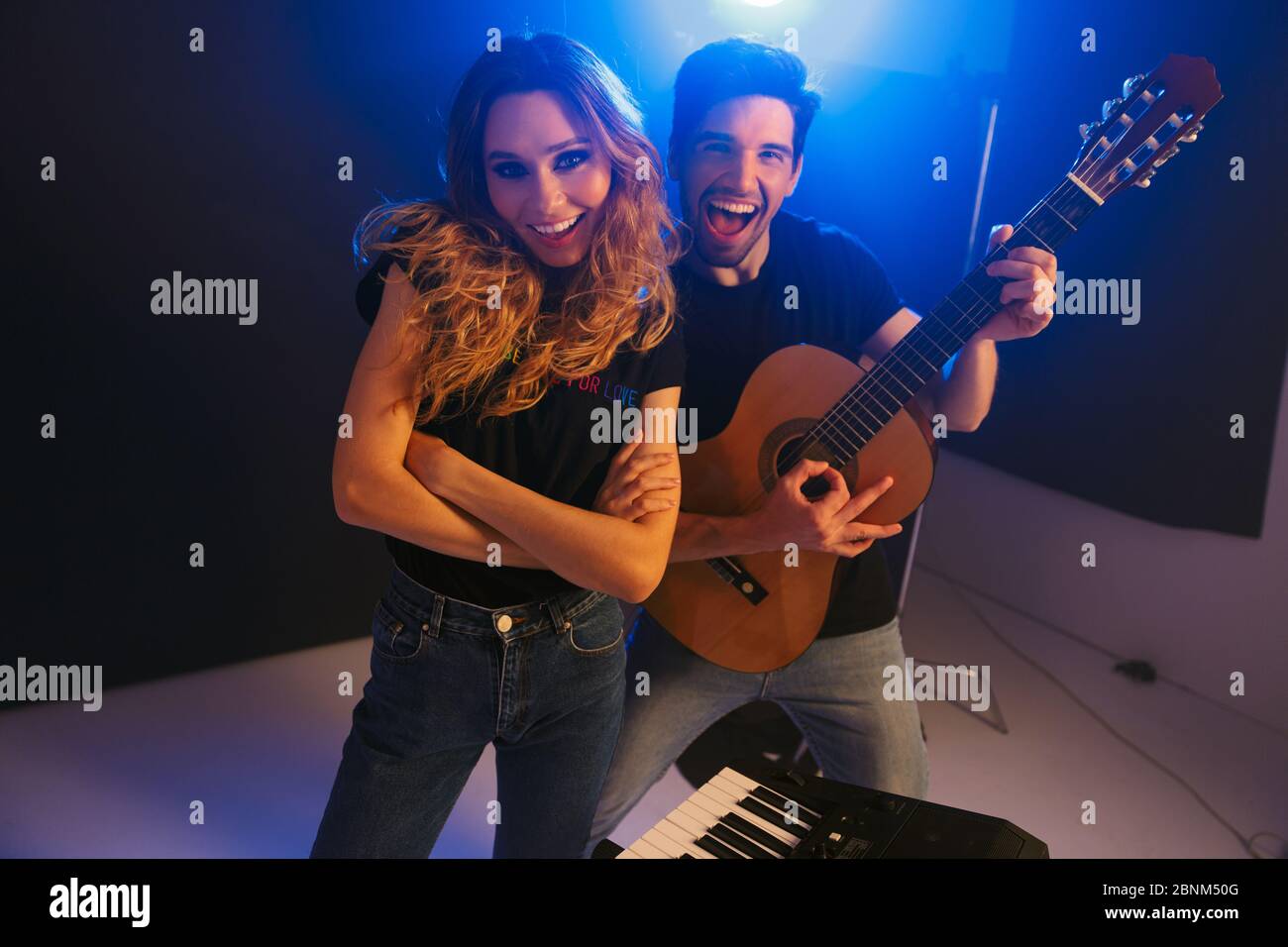 Image of young cheerful positive happy loving couple musicians group ...