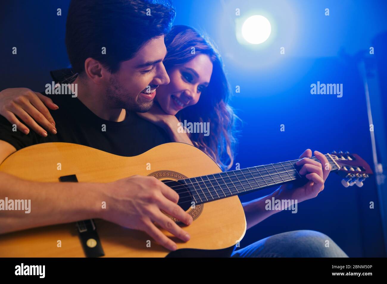 Image of a happy young loving couple musicians with guitar on scene in ...
