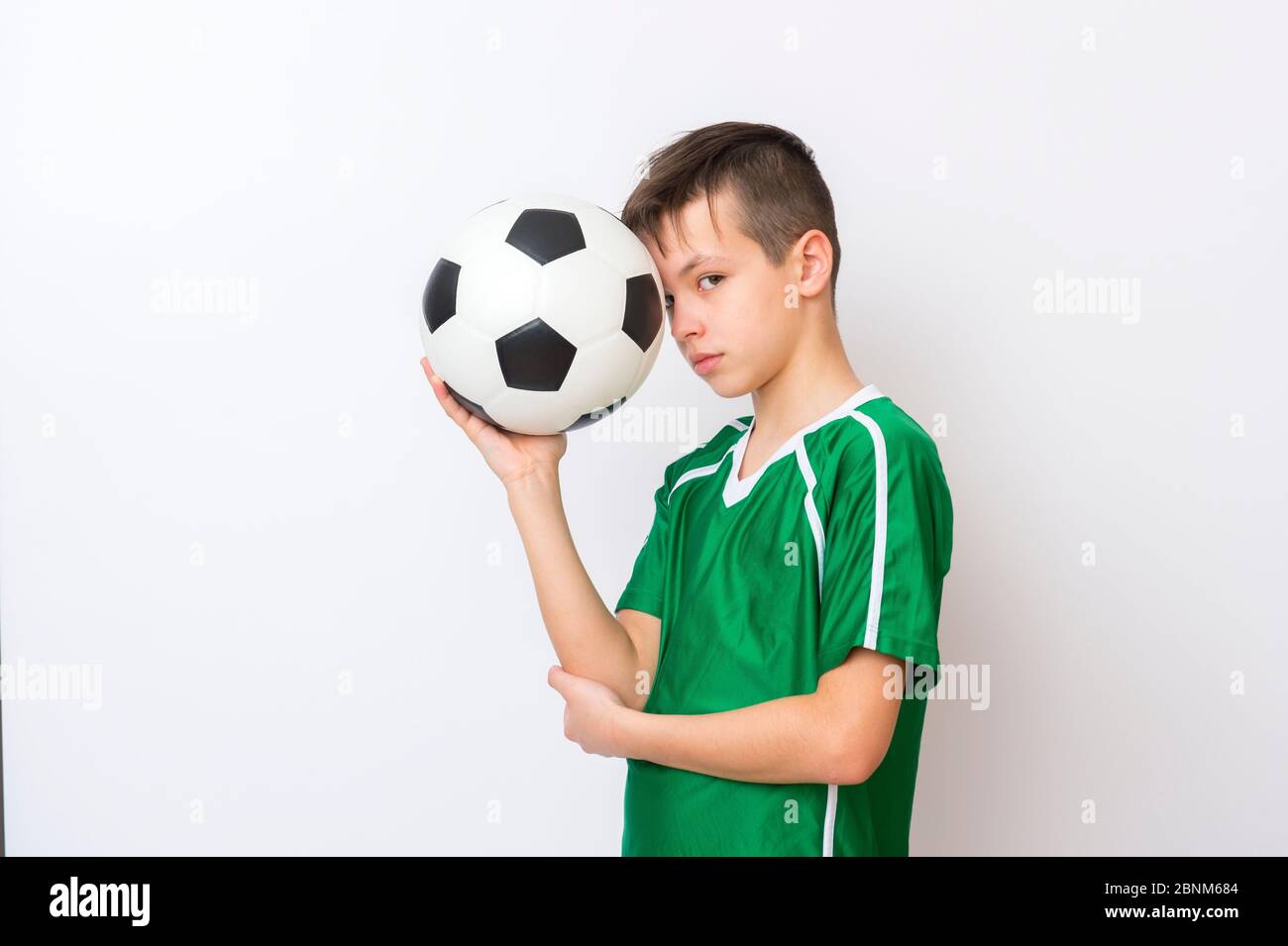 Sad kid with soccer ball over white background. Kid activities.Training ...