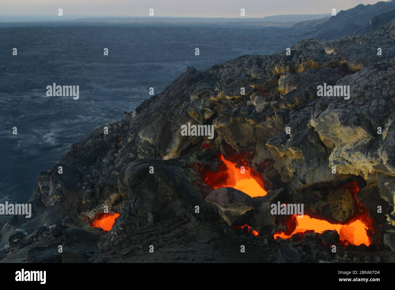 Skylights in the roof of a lava tube reveal the red hot liquid lava ...