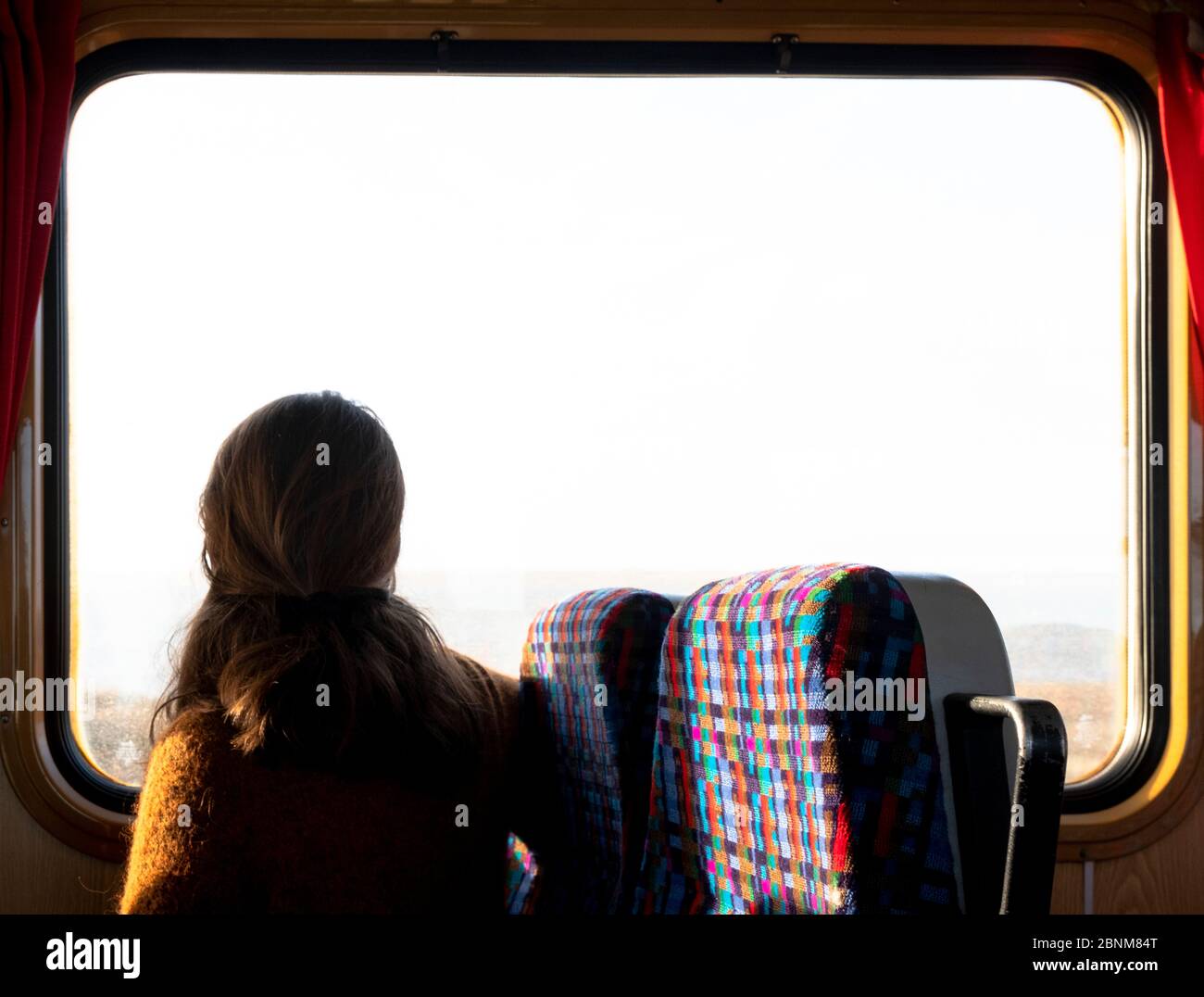 Brunette woman looks out of the train window Stock Photo - Alamy