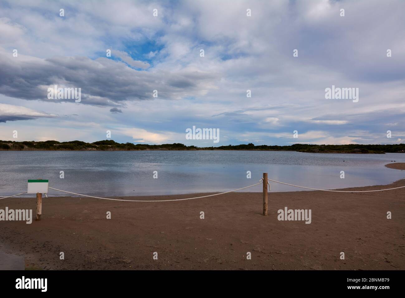 Lake with calm waters after the storm, dramatic clouds, blue sky and ...