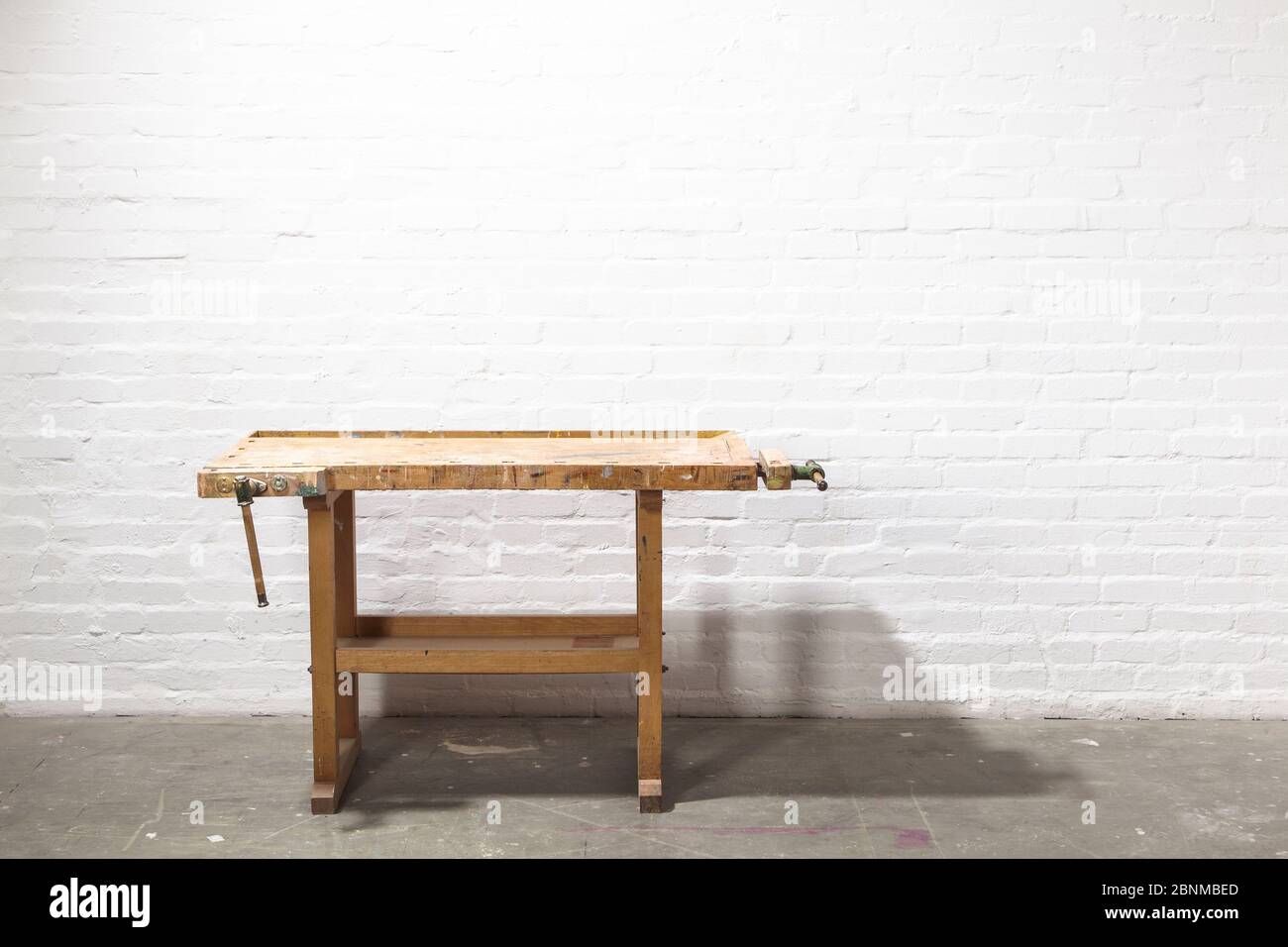 old workbench in workshop, brick wall white, floor gray, light Stock ...