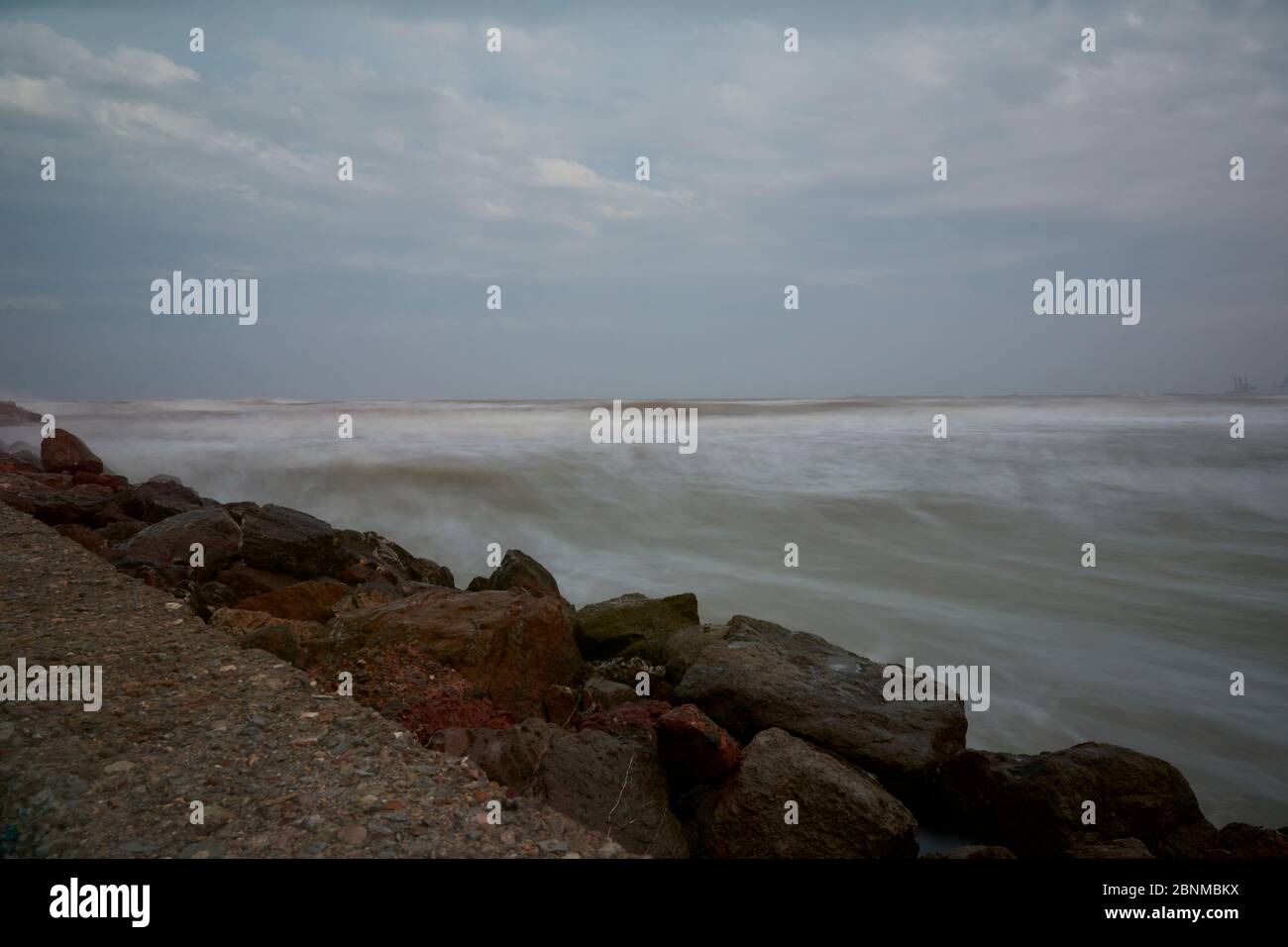The sea from the jetty on a stormy day, rocks, gray, long exposure ...
