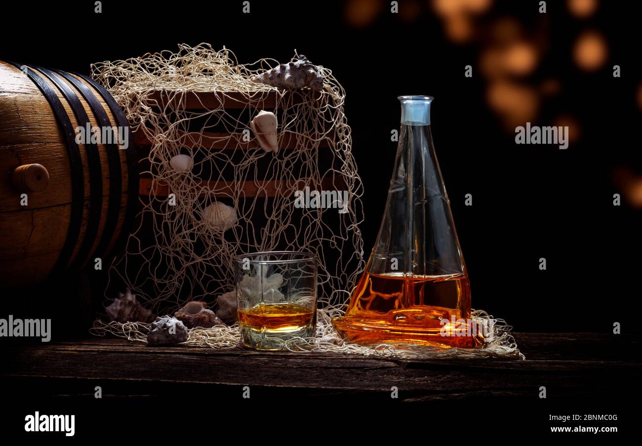 Whiskey bottle and glass in a harbor pub, fishing net, points of light ...