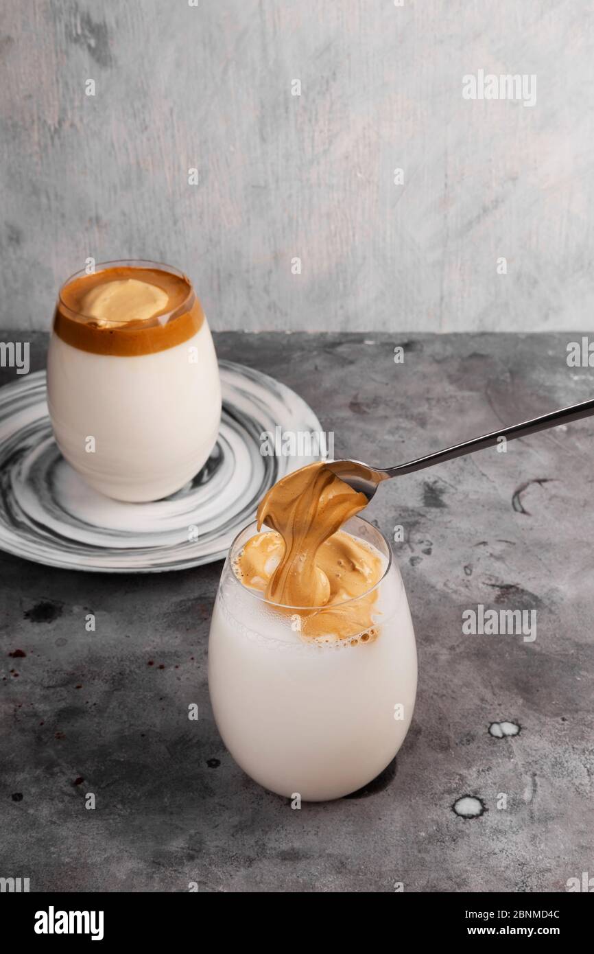 Popular drink Korean Dalgon coffee. Long spoon add lush whipped foam to ...