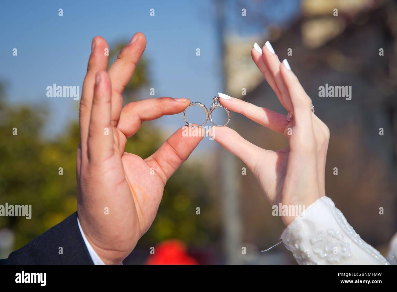 Bride and groom doing the infinity sign combining their wedding rings ...